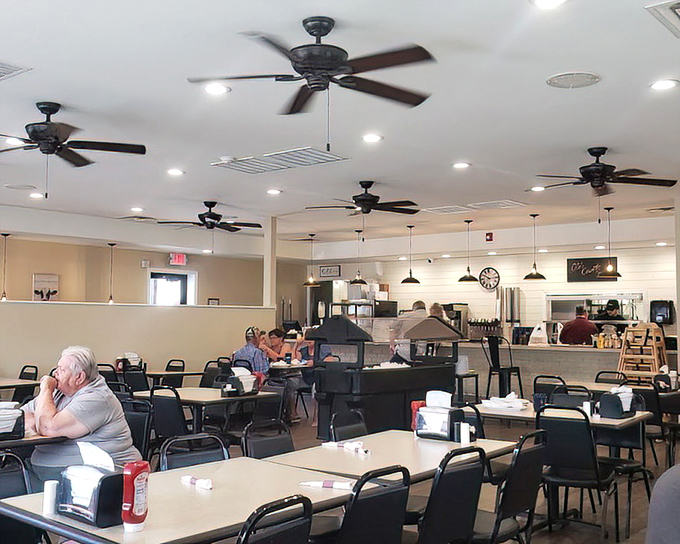 Morning light streams through windows onto tables where countless cups of coffee have fueled conversations both profound and perfectly pointless. Democracy in diner form.