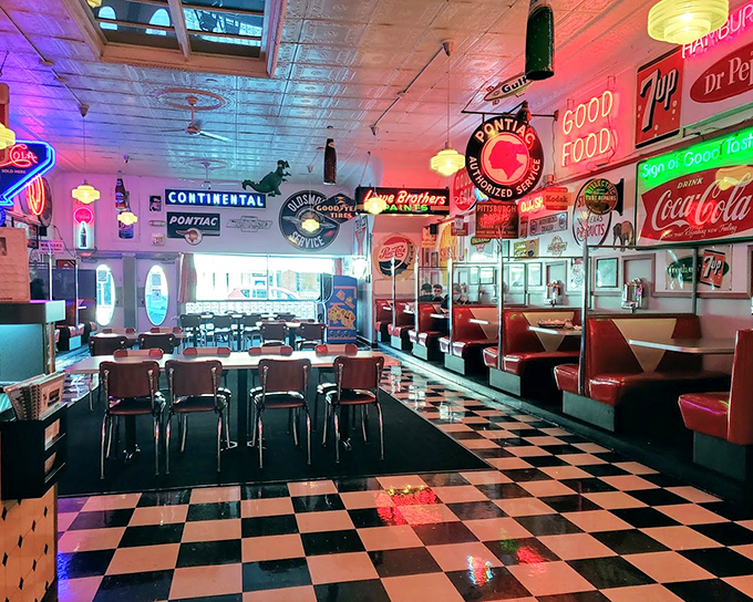 The dining room glows with neon nostalgia, where every vintage sign tells a story and every red vinyl booth has hosted countless family dinners and first dates.