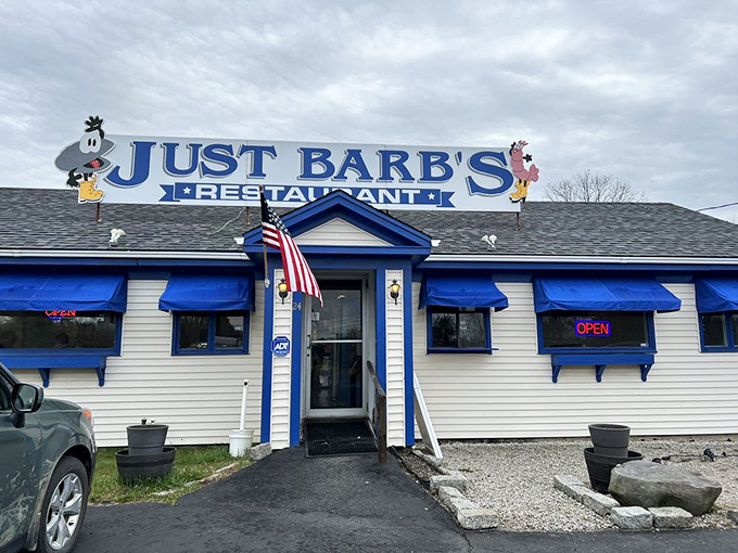 The welcoming entrance with its American flag and bright blue awnings beckons hungry travelers like a lighthouse guiding ships to safe harbor.