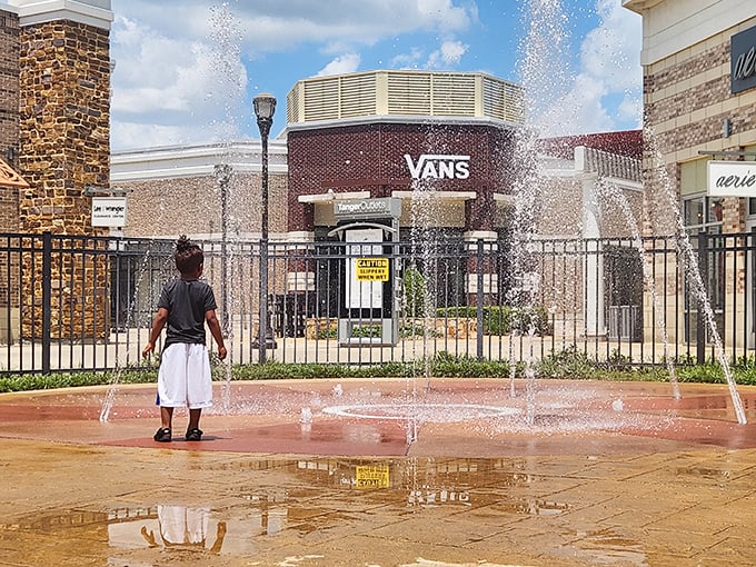 A young shopper finds joy in the dancing fountains—proof that Tanger offers entertainment for all ages between bargain hunts.