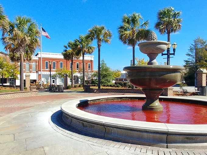 The town fountain creates a gathering spot where palm trees and brick buildings frame picture-perfect Southern moments.