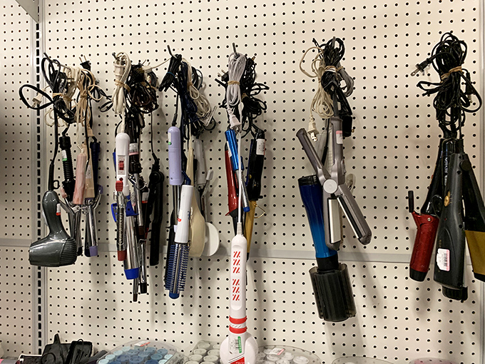 The hair tool graveyard &ndash; where curling irons and blow dryers hang like strange mechanical fruit. Beauty implements awaiting their second styling chance.