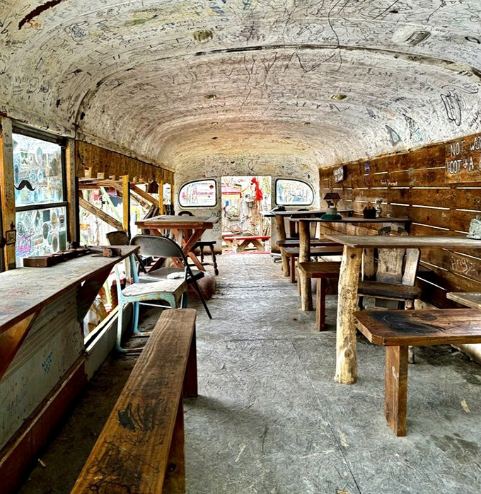 Another angle of bus dining reveals rustic wooden benches and walls covered in visitors' signatures. Not just a meal&mdash;it's leaving your mark on Appalachian food history.