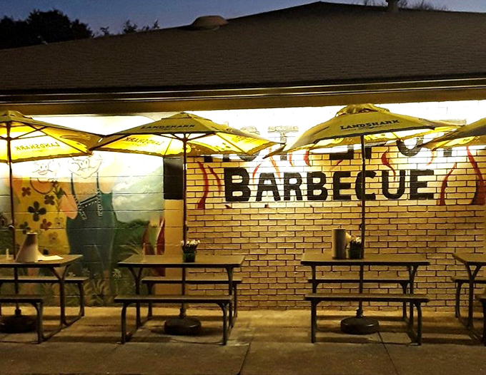 As evening falls, the patio transforms into a barbecue oasis. Those yellow umbrellas are like beacons guiding hungry travelers home.