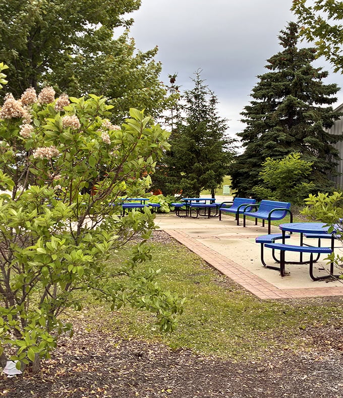 Nature meets retail therapy. These blue picnic tables offer respite for weary shoppers and patient partners who've reached their shopping threshold.
