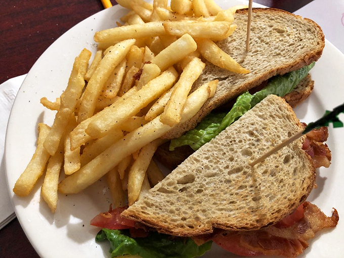 The classic BLT—where bacon, lettuce and tomato perform their timeless dance on toasted bread, while crispy fries stand ready for dipping duty.