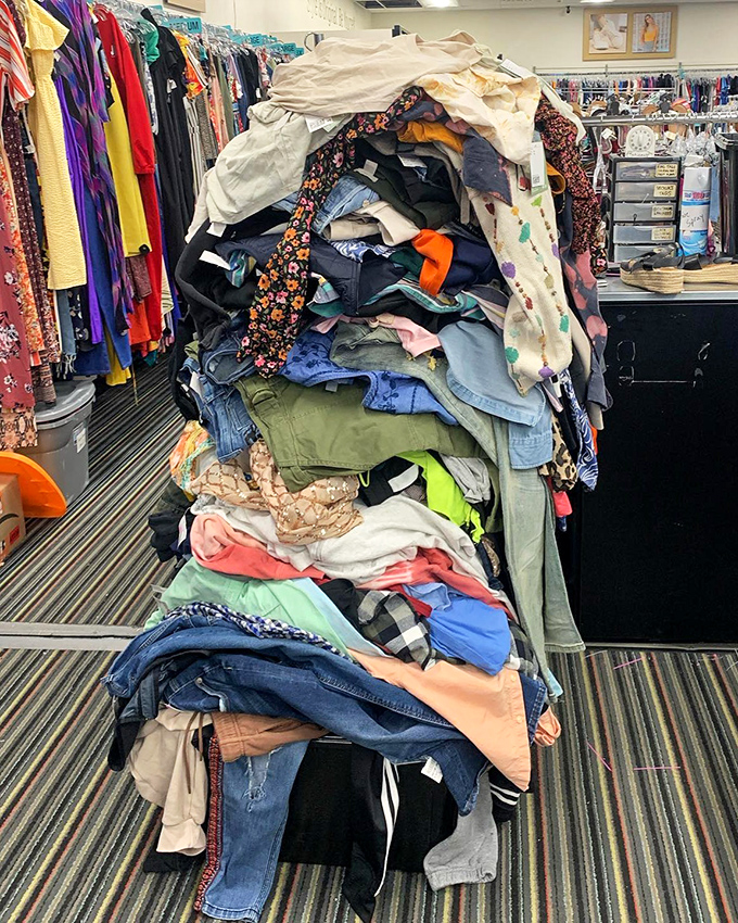 Fashion's version of Jenga – this precarious mountain of clothing awaits sorting, a testament to Rochester's endless supply of style castoffs.