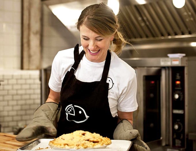 Behind every great pie is a passionate baker with oven mitts and a mission. That smile says, "I've just created something that will make someone's day better."