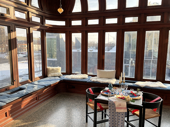 The sunroom combines rich wood paneling with walls of windows, creating a cozy nook where you can imagine sipping glögg while watching snowflakes dance outside.