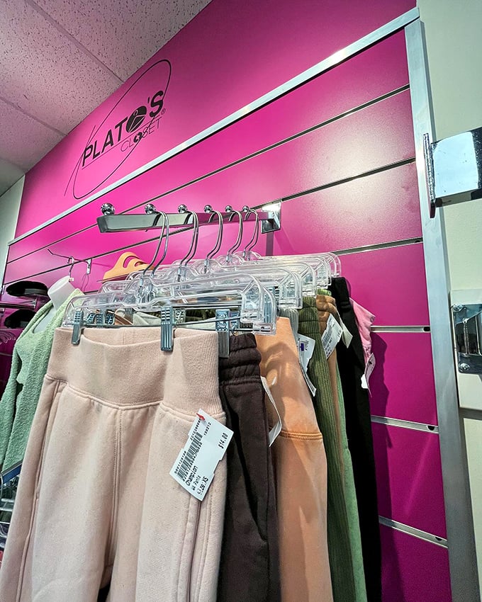 The signature pink wall at Plato's Closet frames a selection of neutral-toned athleisure&mdash;comfort and style hanging in perfect balance.