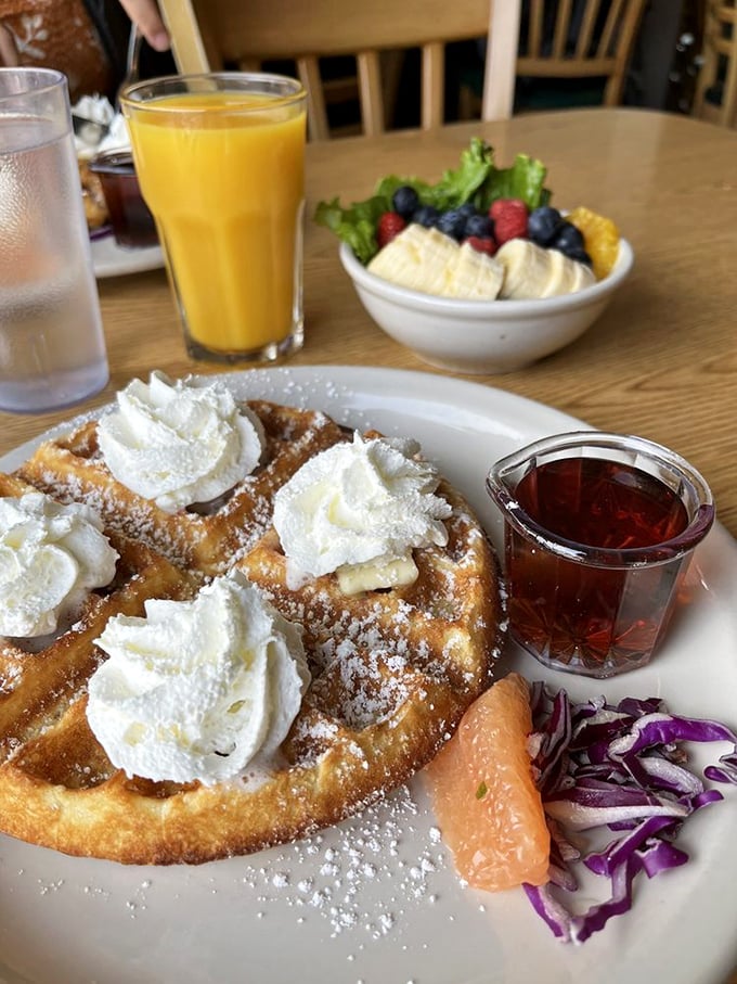 Waffle perfection crowned with clouds of whipped cream. That amber color signals the ideal balance of crisp exterior and tender interior&mdash;breakfast engineering at its finest.