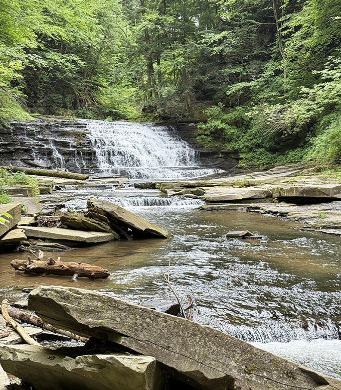 The park's signature waterfall spreads like a lace tablecloth over ancient stone. This multi-tiered cascade creates a natural amphitheater of rushing sound.
