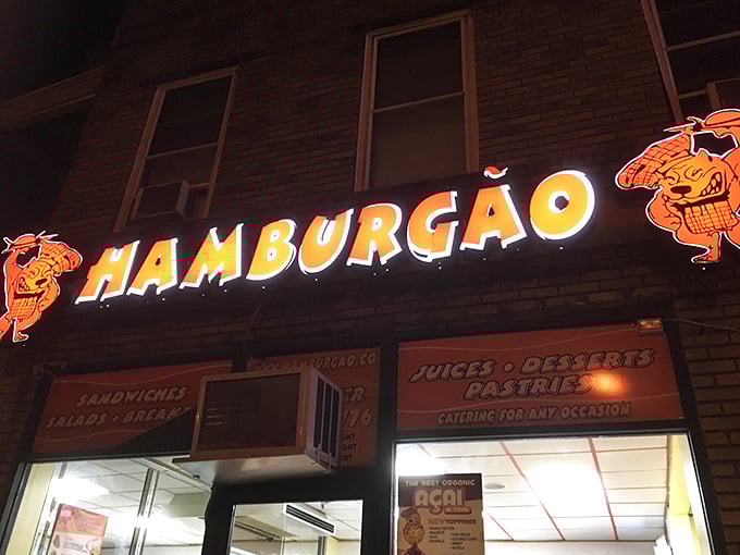 Hamburg&atilde;o's vibrant sign and cartoon mascots light up the night like a burger carnival for your taste buds.