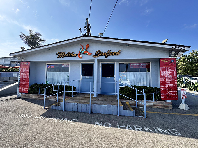 Malibu Seafood's simple white building stands like a lighthouse for hungry travelers. That little red lobster sign promises big flavor inside!
