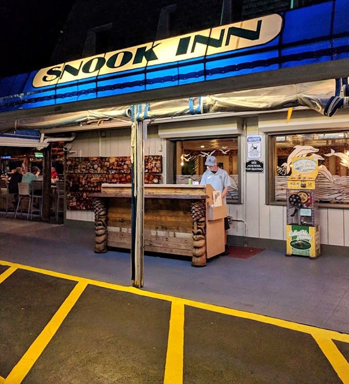 Snook Inn's nighttime takeout window glows with welcoming light. Even after dark, this Marco Island favorite reels in hungry seafood lovers!