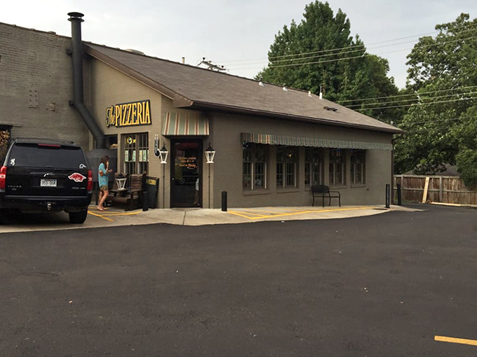 The Pizzeria's classic tan building with striped awnings whispers rather than shouts, confident its pizza speaks volumes.