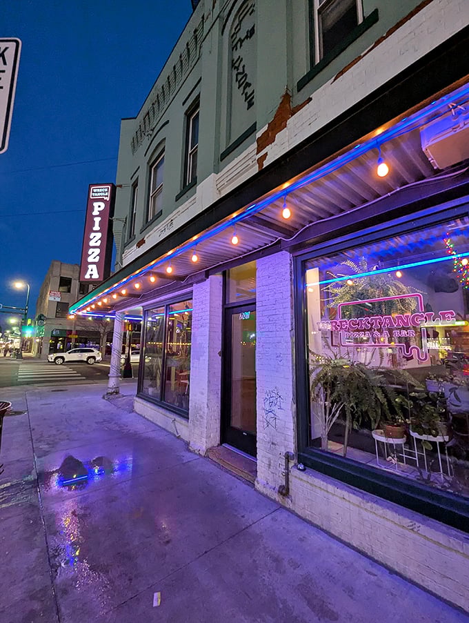 Wrecktangle's mint-green building and neon lights create a distinctive urban vibe for their Detroit-style pizza experience.