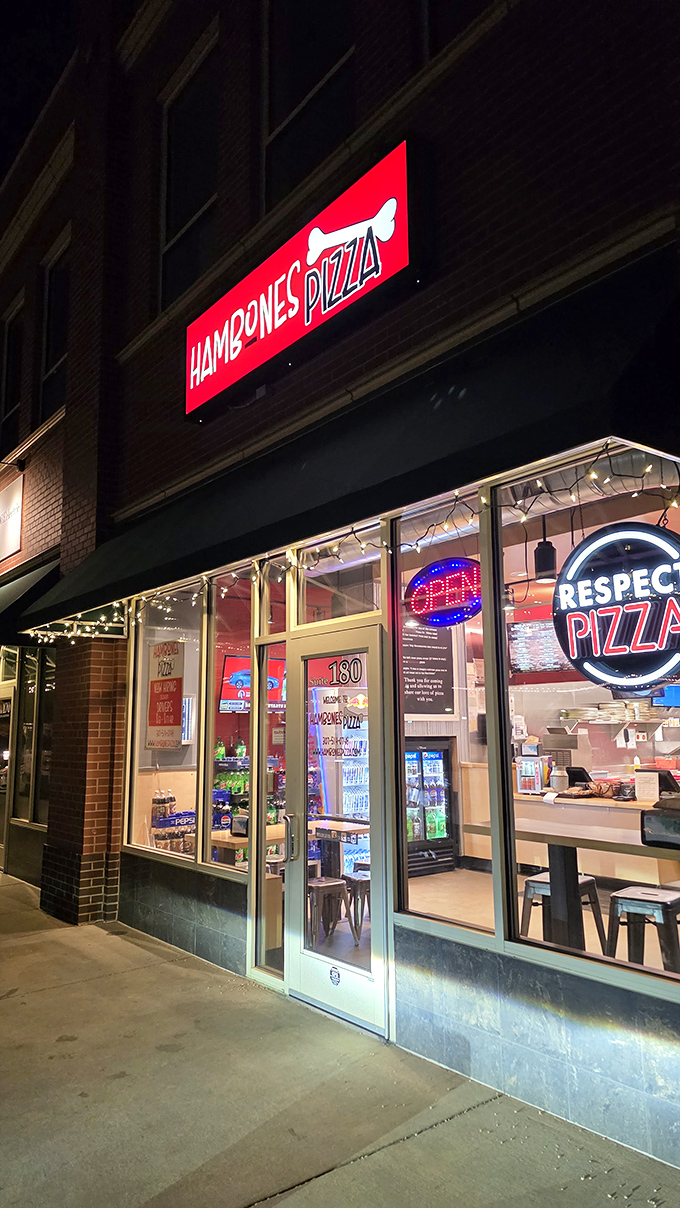 "Respect Pizza" glows like a neon mantra! This sleek, contemporary space elevates the humble pizza to art form status.