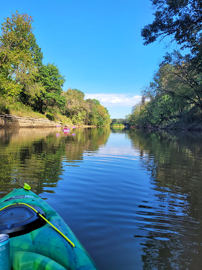 Paddling down this mirror-smooth river feels like gliding through a Thomas Kinkade painting come to life.