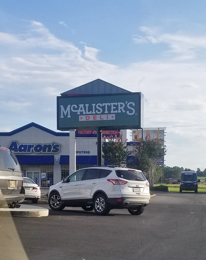 This McAlister's sign towers above the parking lot, a beacon guiding hungry travelers toward sandwich satisfaction.