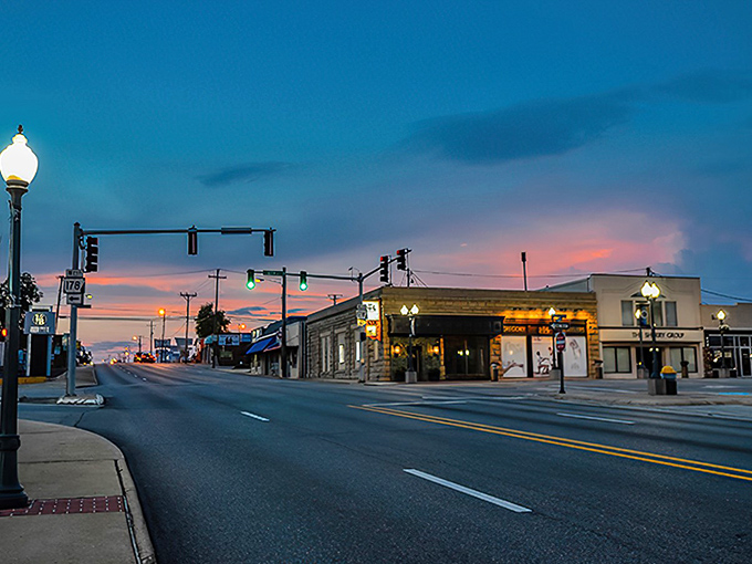 Sunset transforms Mountain Home's main street into a painting, with golden light warming the stone buildings as day transitions to evening.