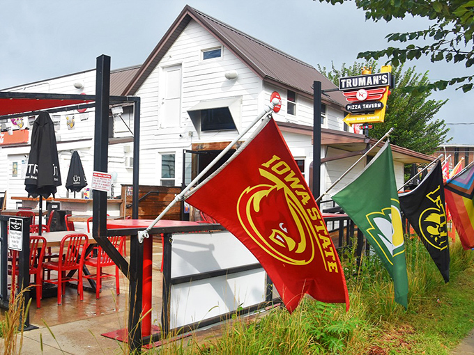 Truman's colorful flags flutter like a celebration of pizza possibilities. This humble white building houses bold, unforgettable flavors.