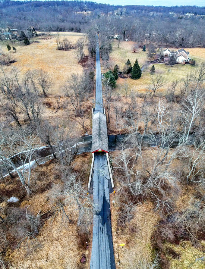 From above, the bridge appears as a thin red line connecting patches of countryside&mdash;a human brushstroke on nature's canvas.