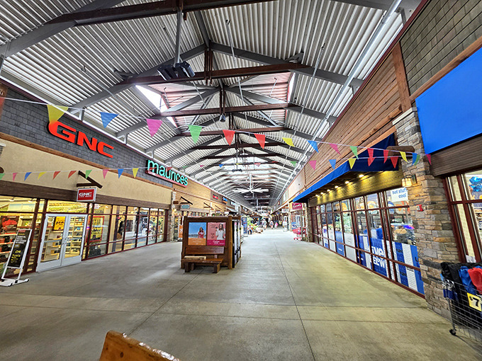 The covered walkway stretches like a runway of retail possibilities. Colorful banners and storefronts beckon shoppers into their domains.