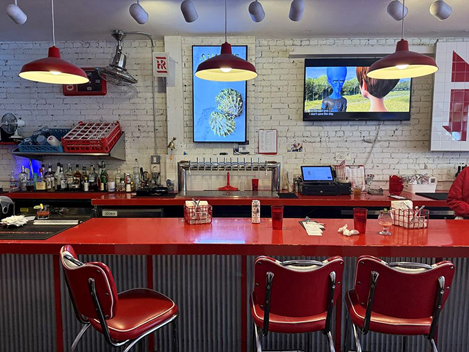 The bar area gleams with red accents against white brick. Those pendant lights aren't just illuminating space&mdash;they're spotlighting culinary stardom.