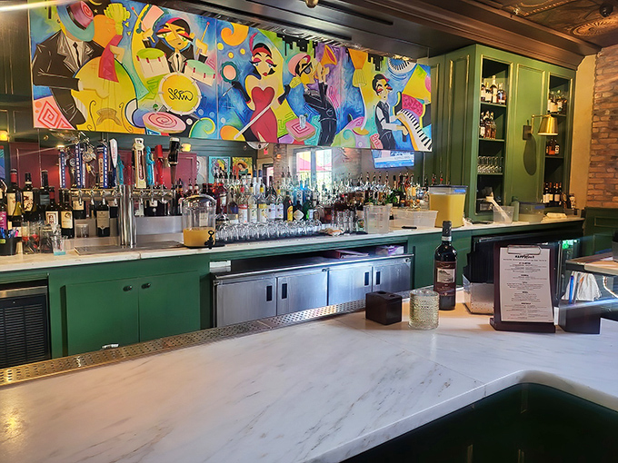 That vibrant bar mural brings the energy while the green cabinetry keeps things grounded, like art meeting practicality for drinks.