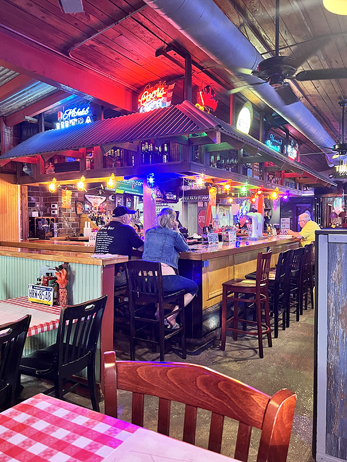 The bar glows with neon nostalgia, creating the perfect backdrop for stories that get better with each telling and each sip.