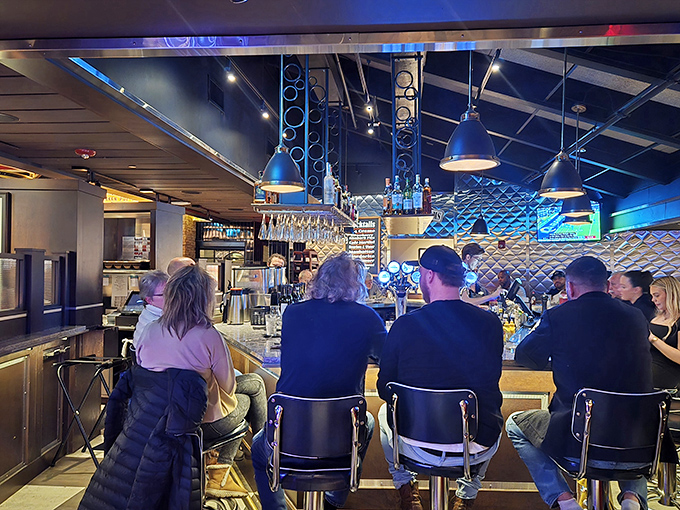 The bar area beckons with blue lighting and the promise of expertly crafted drinks – a modern speakeasy within a retro diner.