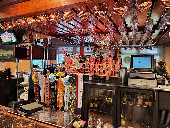 Bar heaven: where spirits line up like soldiers ready for duty. The hanging glasses catch the light, creating a boozy chandelier effect that says "good times ahead."