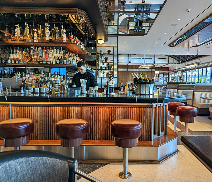 Mid-century modern meets contemporary comfort in this dining area, where the green walls and framed memories create a backdrop for making your own.