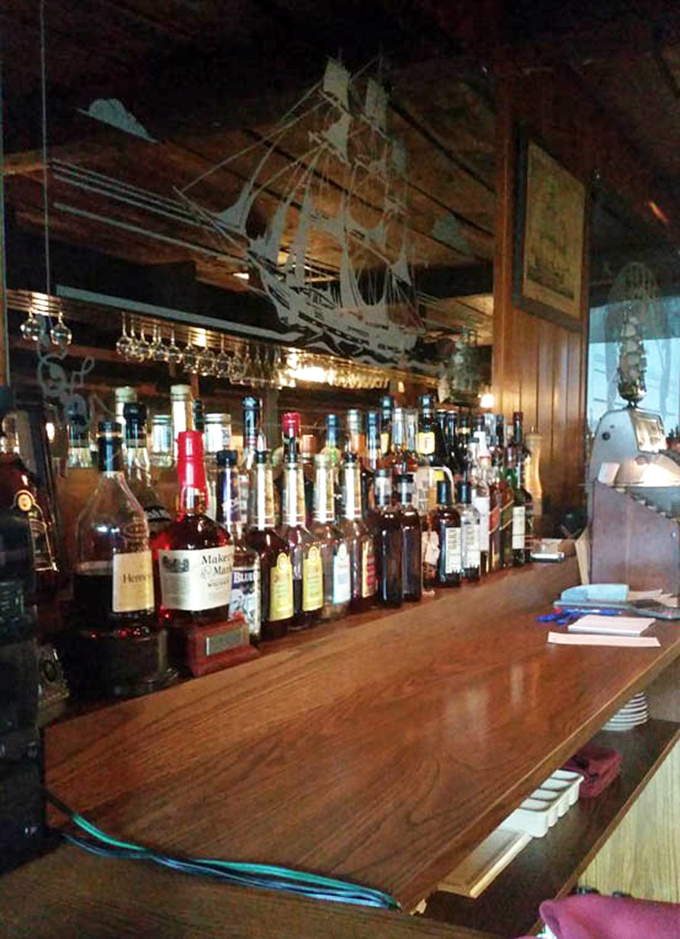 Bottles lined up like sailors at attention. That model ship above isn't decoration—it's keeping watch over your maritime drinking experience.