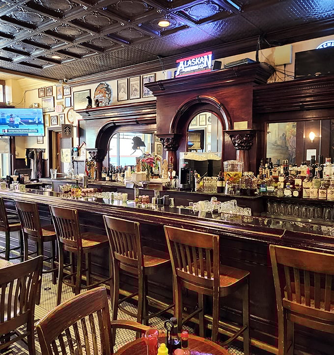 The bar isn't just serving drinks; it's preserving history with every pour, that carved wooden archway having witnessed more toasts than a wedding reception.
