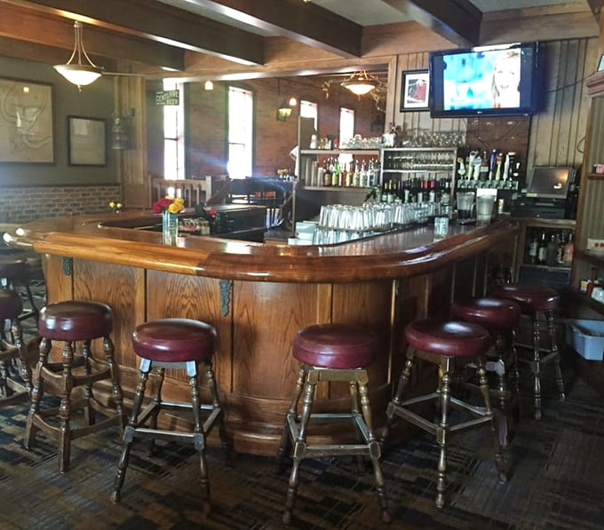 The curved wooden bar invites you to pull up a stool and settle in for stories, spirits, and the kind of hospitality that can't be manufactured.