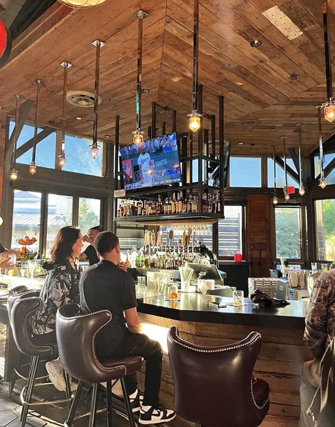 The bar beckons with gleaming bottles and pendant lights, promising perfectly crafted drinks for every palate preference.