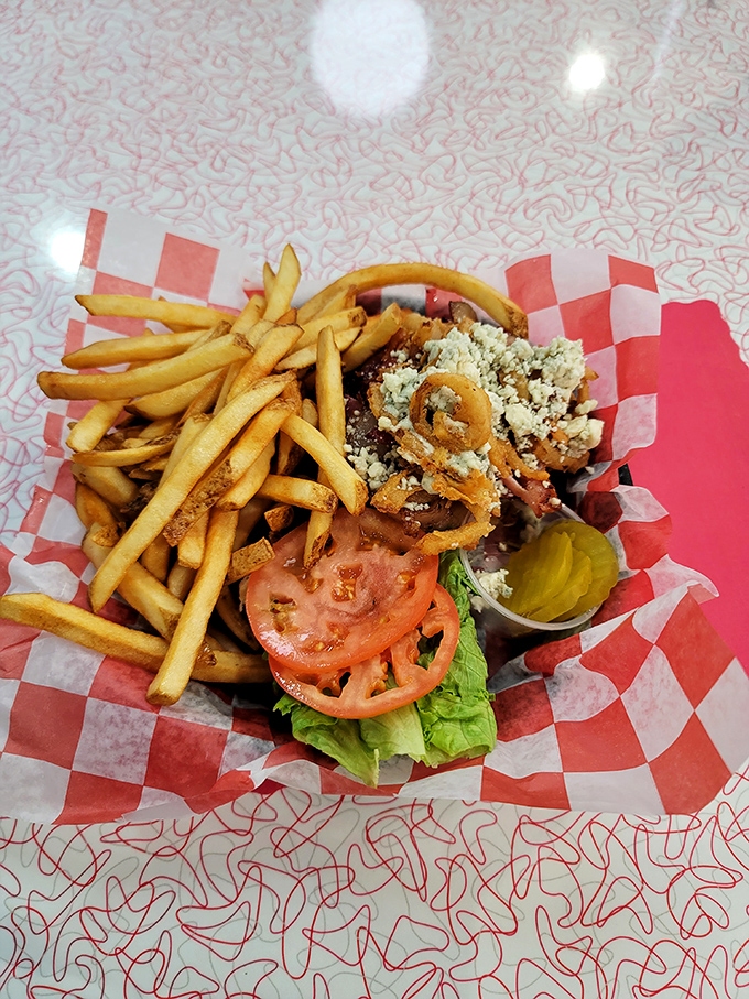 The Blue Moon Burger arrives like a savory planet in its own culinary solar system, orbited by perfectly crisp french fries.