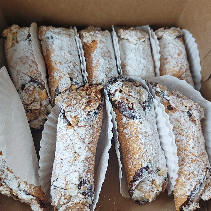 Powdered sugar-dusted cannoli lined up like delicious soldiers, ready to march straight into your heart (and stomach).