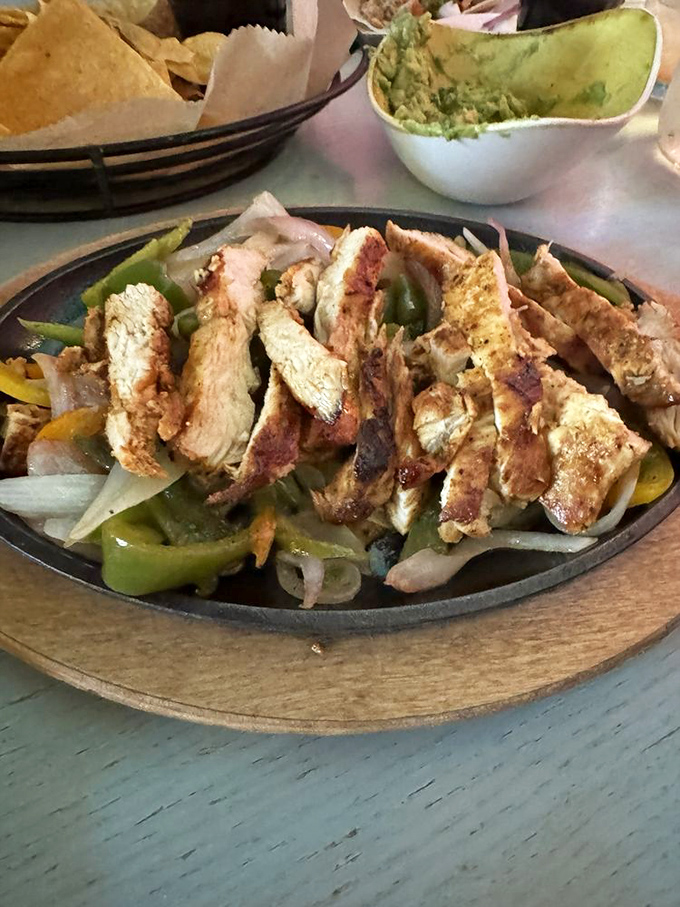 Chicken fajitas arranged with the precision of a small art installation. Each slice promises smoky, charred perfection against sweet peppers and onions.