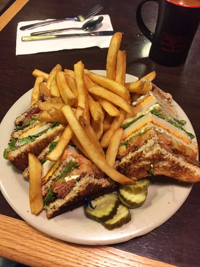 This club sandwich isn't playing around—it's a skyscraper of flavor with enough french fries to make you forget salads ever existed.
