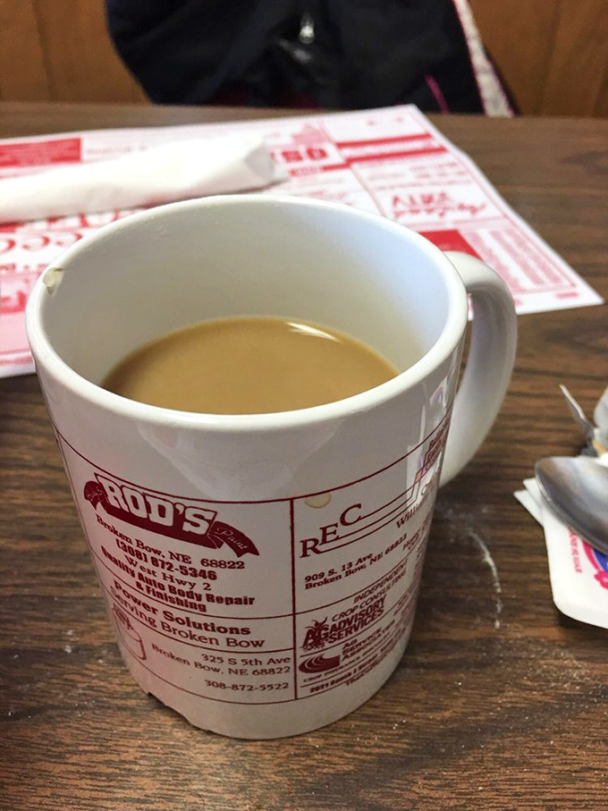Coffee served in a mug advertising local businesses &ndash; peak small-town charm that somehow makes the coffee taste even better.
