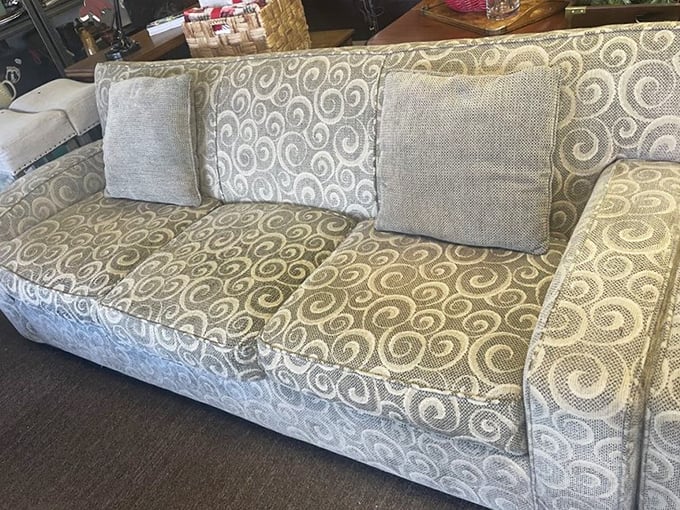 A scrollwork-patterned couch that looks barely used sits pretty with coordinating pillows&mdash;proof that someone else's redecorating impulse is your decorating jackpot.