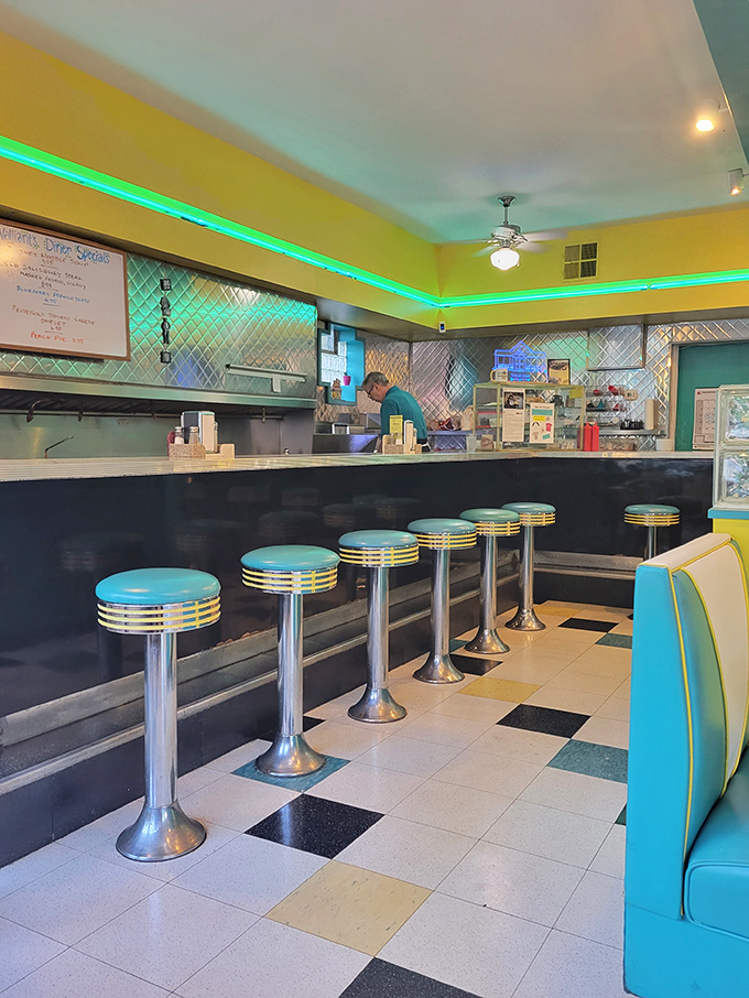 The neon accent lighting casts a nostalgic glow over turquoise counter stools that have supported generations of Pittsburgh posteriors. Comfort never goes out of style.