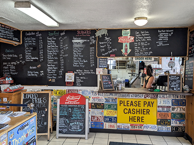 Order here, dream everywhere. The counter showcases decades of desert dining wisdom and license plates that could tell stories better than most novels.