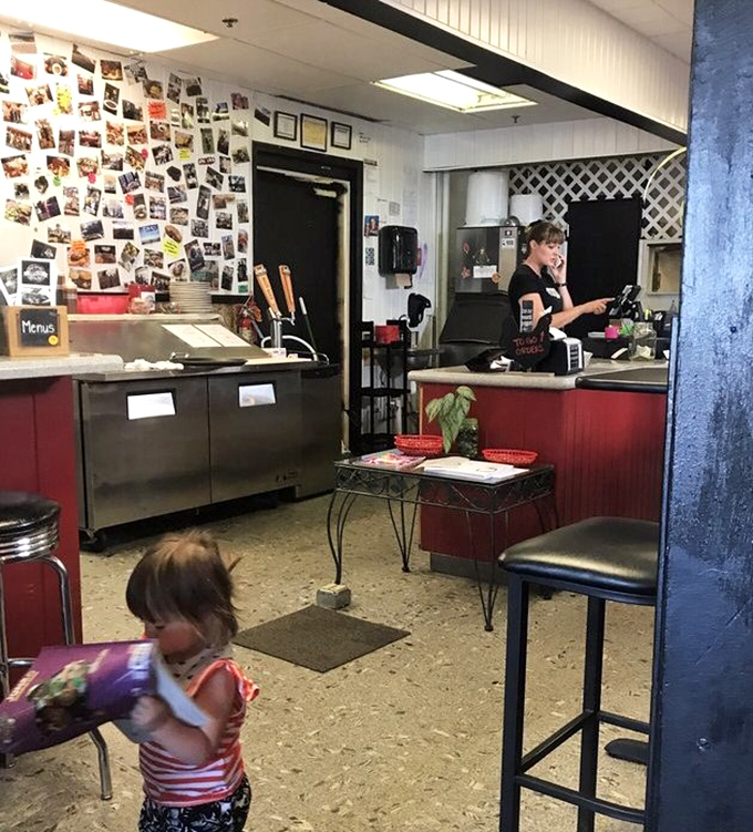 The counter area where all the magic happens, complete with customer photos proving this place creates loyal fans daily.