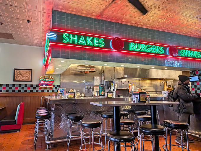 More neon, more promise. The open kitchen concept means you can watch your burger take its ceremonial dip into culinary history.
