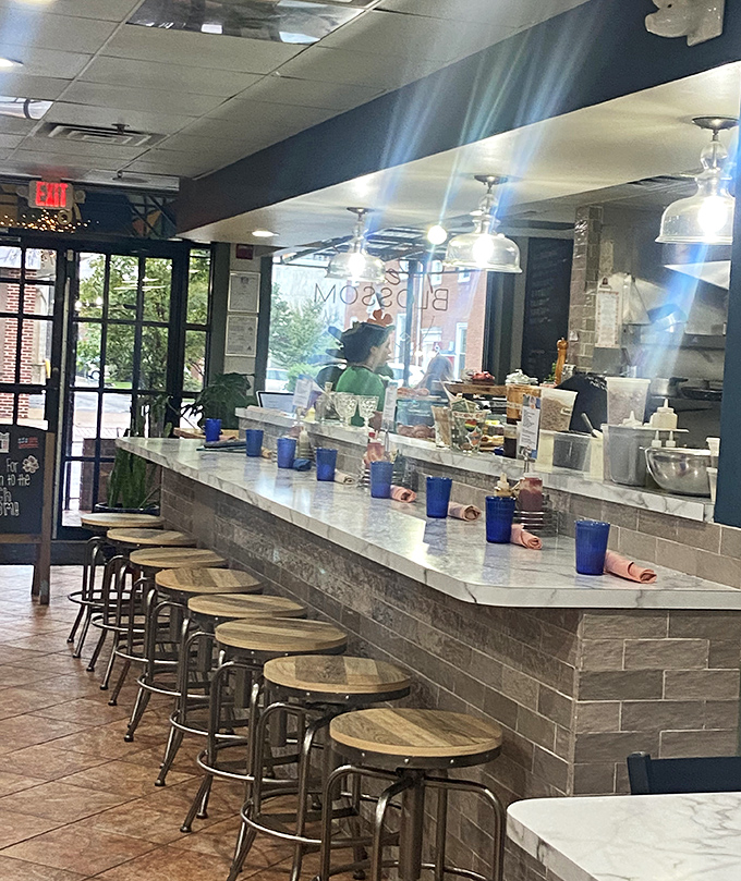 Counter seating: where breakfast voyeurs can watch culinary magic happen while sipping coffee from those signature blue glasses.