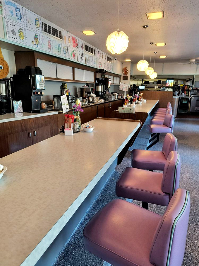 The counter seats offer front-row tickets to the breakfast ballet, where coffee flows and pancakes pirouette through the air.